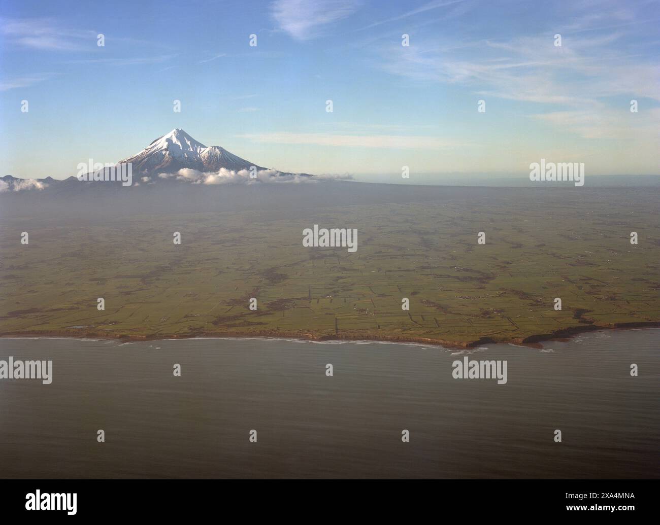 This is an aerial view of a vast landscape featuring a prominent snow ...