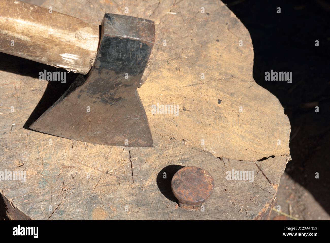The ax is hammered into a wooden deck. Next is a hammered anvil for ...