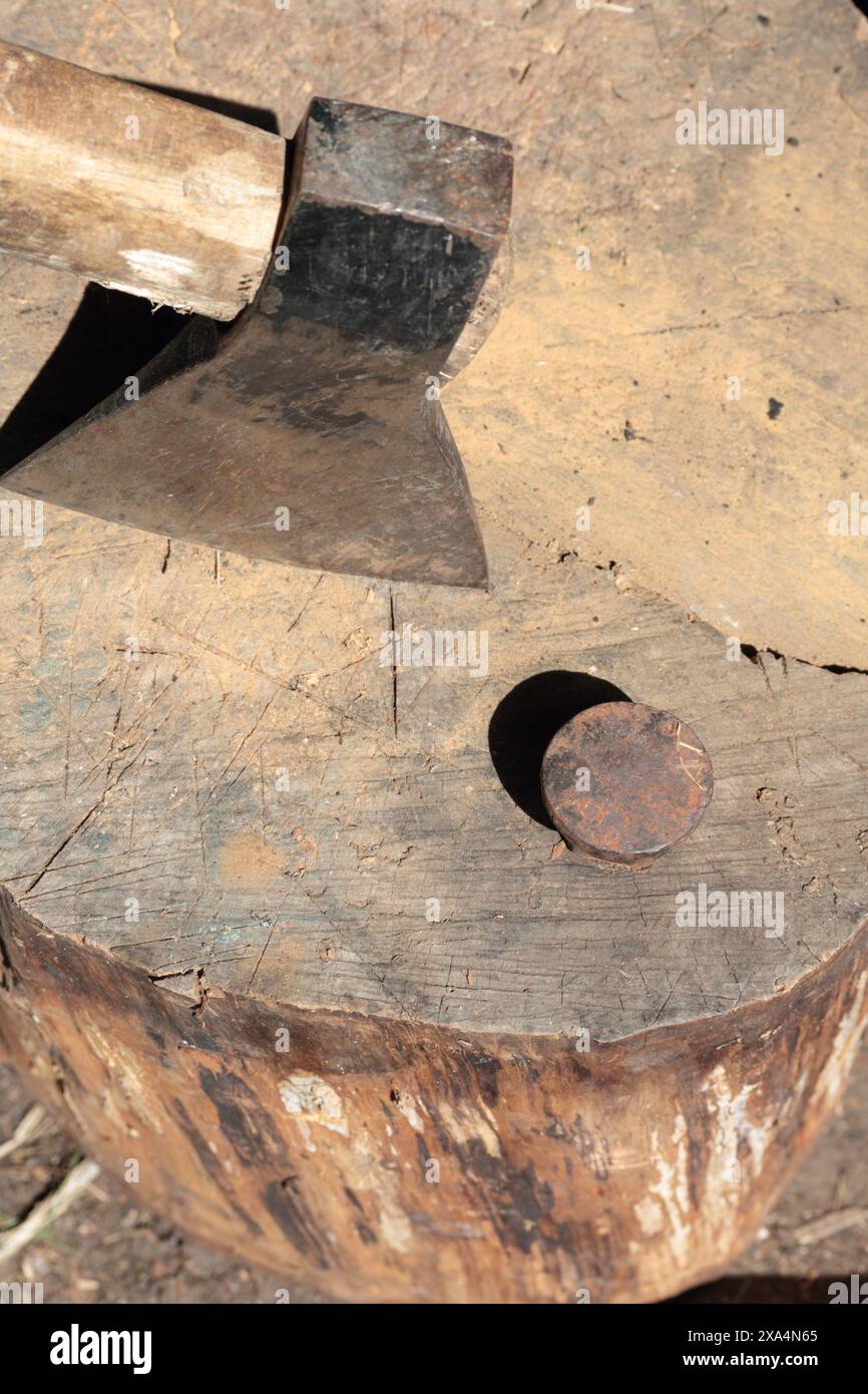 The ax is hammered into a wooden deck. Next is a hammered anvil for ...