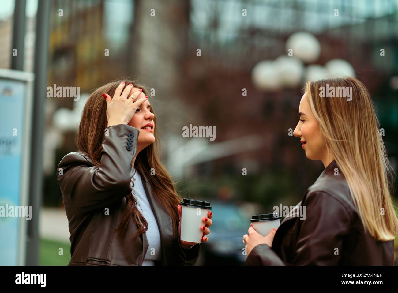 Two businesswomen enjoying a coffee break outside their office Stock ...