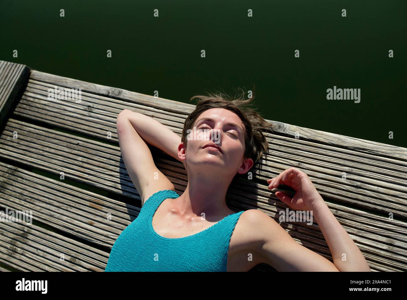 Young woman sunbathing wooden dock over water hi-res stock photography ...