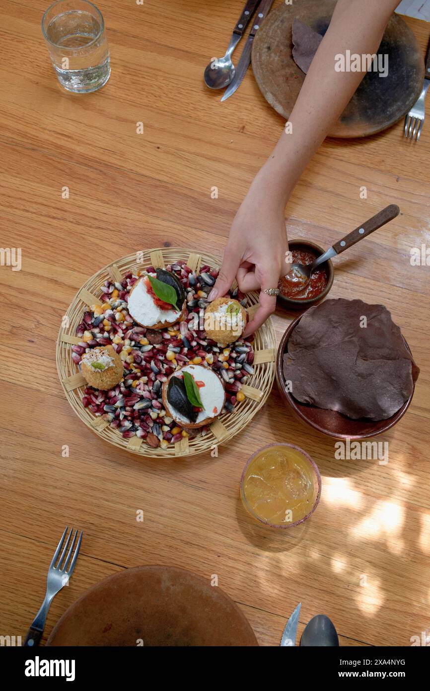 Persons hand reaching out colorful mexican meal woven plate hi-res ...
