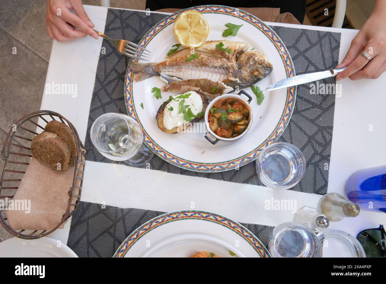 Person dining al fresco plate grilled fish accompanied by lemon hi-res ...