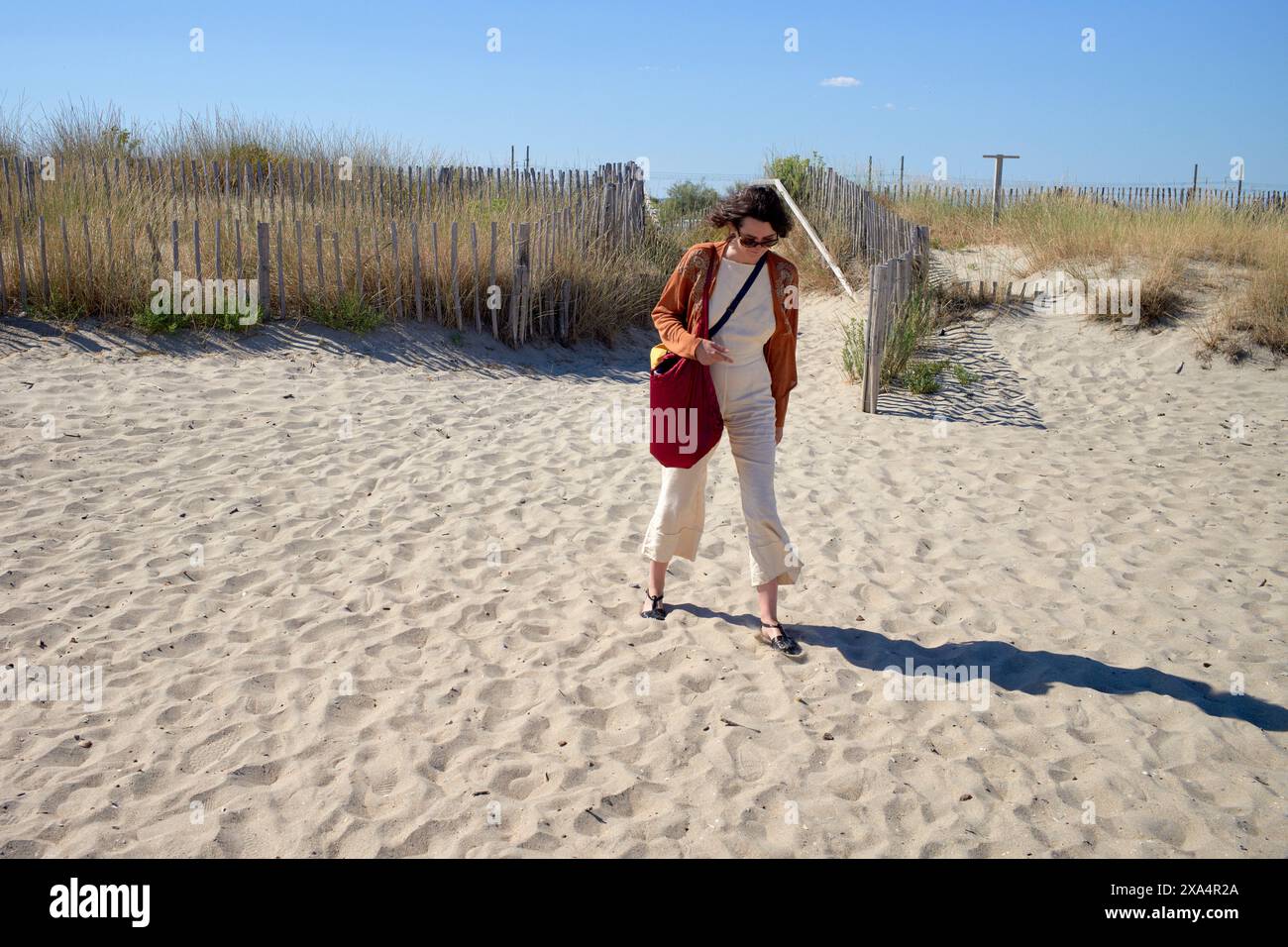 Young woman walking sandy beach path next wooden fences hi-res stock ...