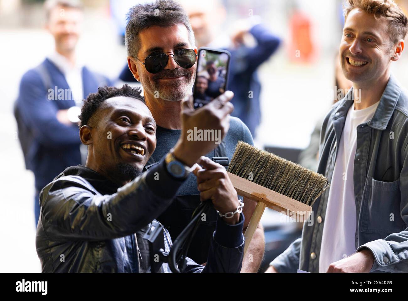 EDITORIAL USE ONLY Simon Cowell with fans as he 'installs' a billboard ...