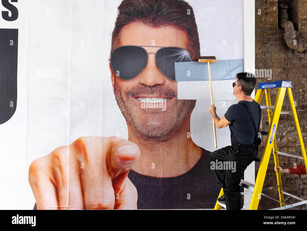 EDITORIAL USE ONLY Simon Cowell 'installs' a billboard in London as he ...