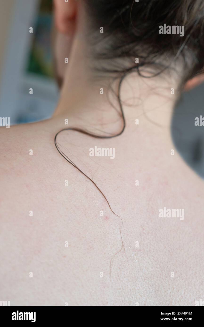 Close-up view of a person's neck and upper back showing a single strand ...