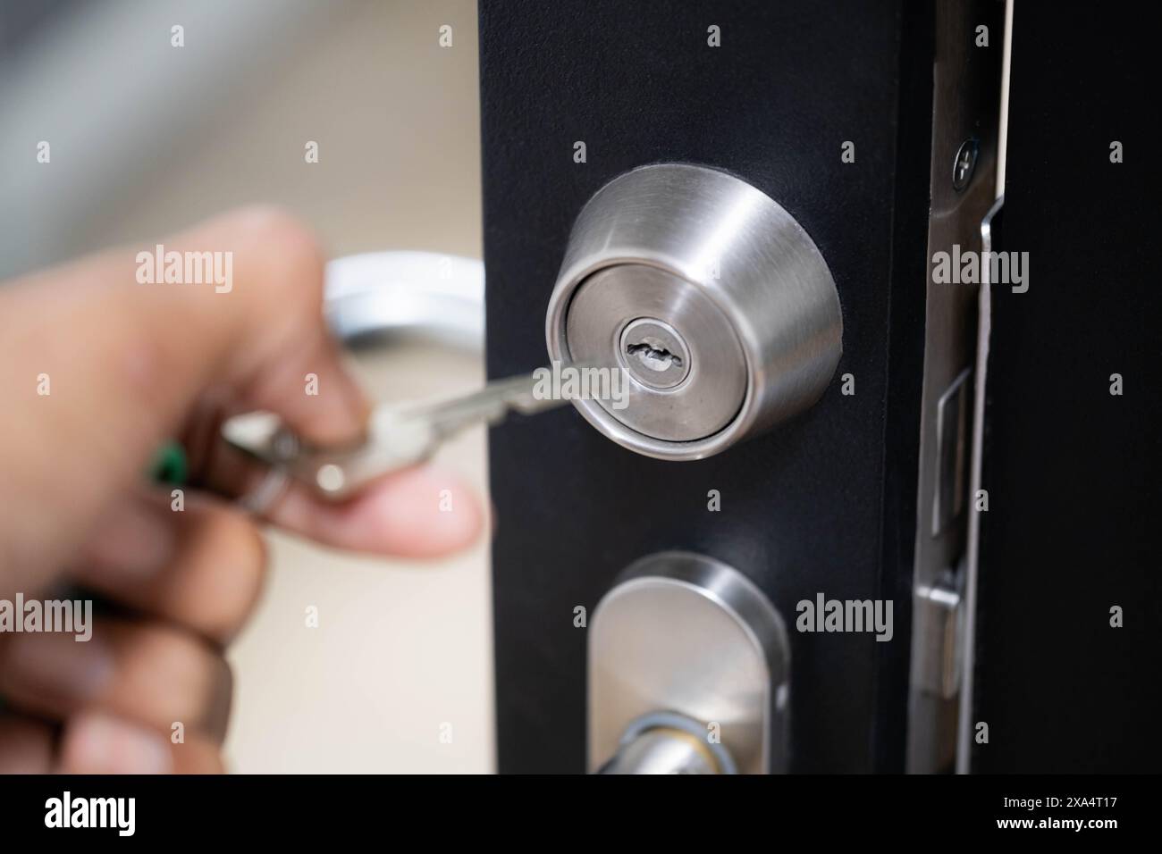 Close-up of a hand inserting a key into a door lock Stock Photo - Alamy