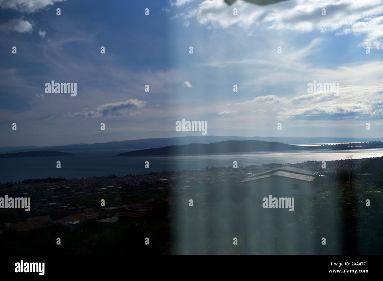 Sunlight streaming through clouds over a coastal town with a clear view ...