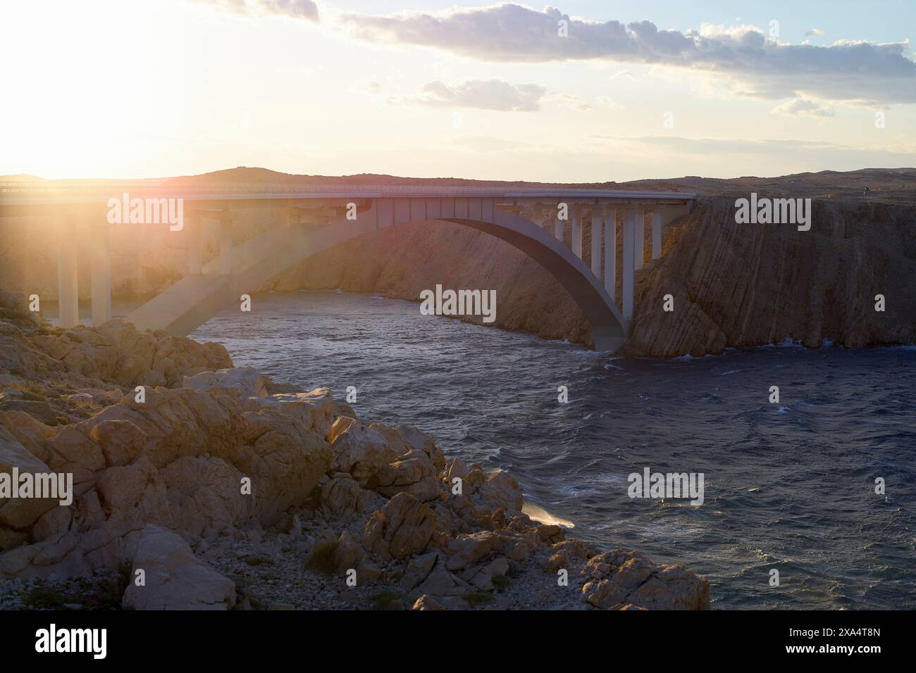 Sunset glow illuminating an arched bridge over a tranquil river with ...