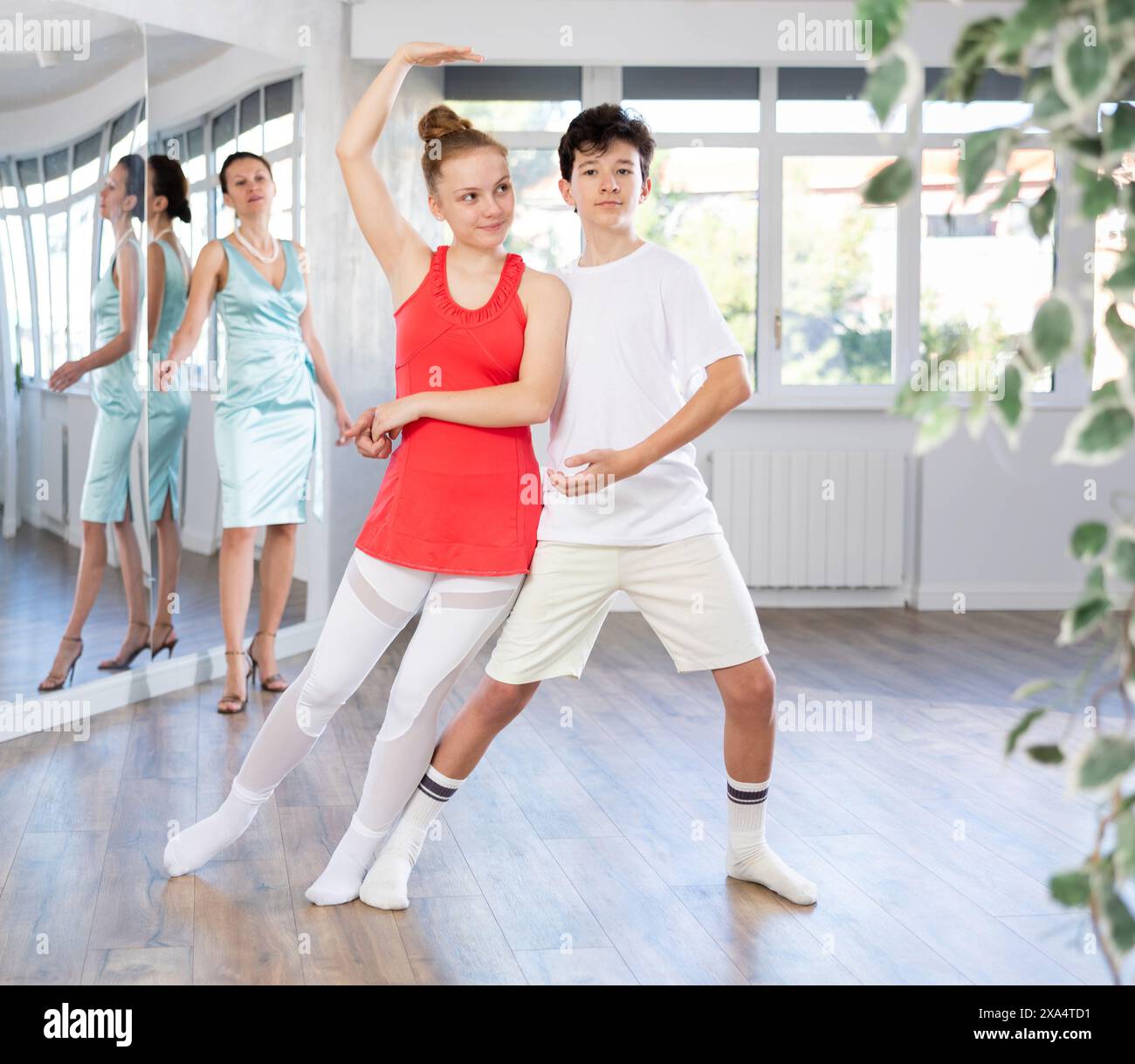 Adolescent dance duo, boy and girl, refining slow foxtrot with female ...