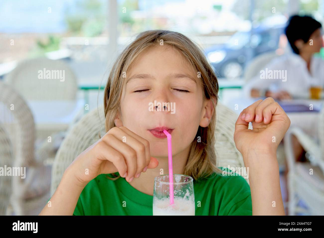 A child enjoys a milkshake with eyes closed and a blissful expression ...