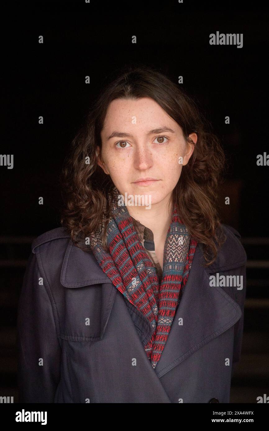 Portrait of a young woman with curly hair wearing a dark coat and ...