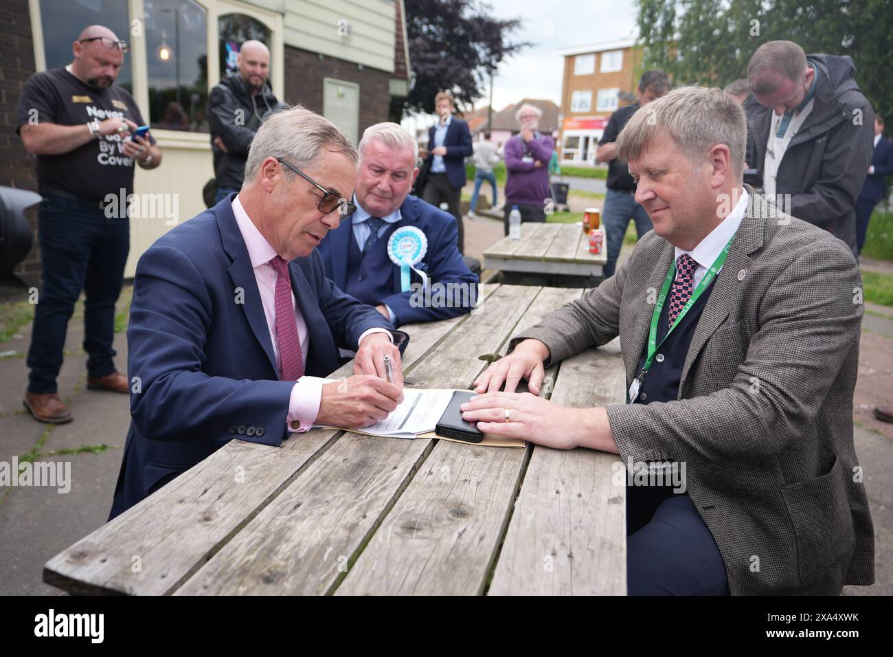 Leader of Reform UK Nigel Farage (left) signs candidacy forms outside ...