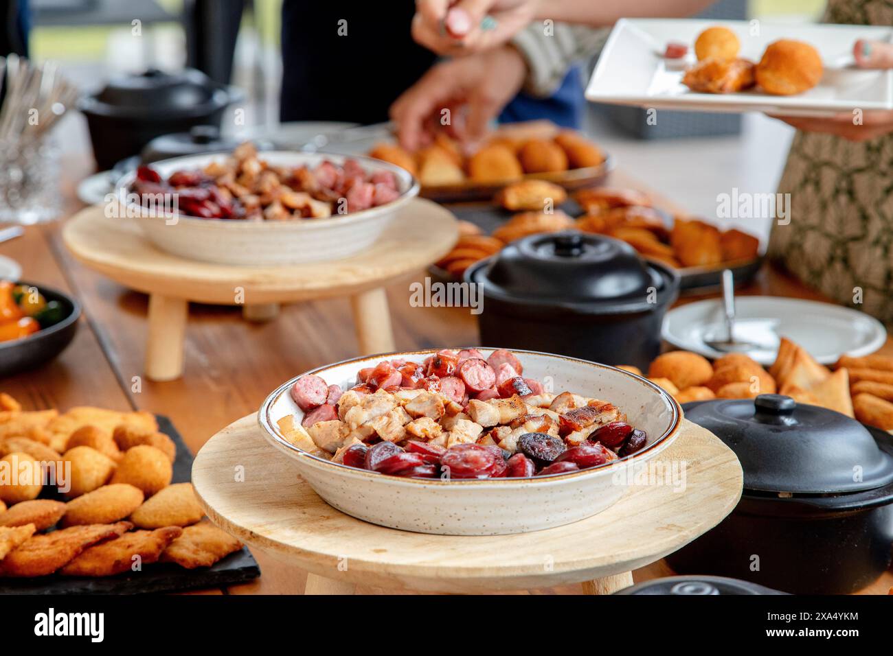 People enjoying a buffet-style meal, serving themselves from a variety ...