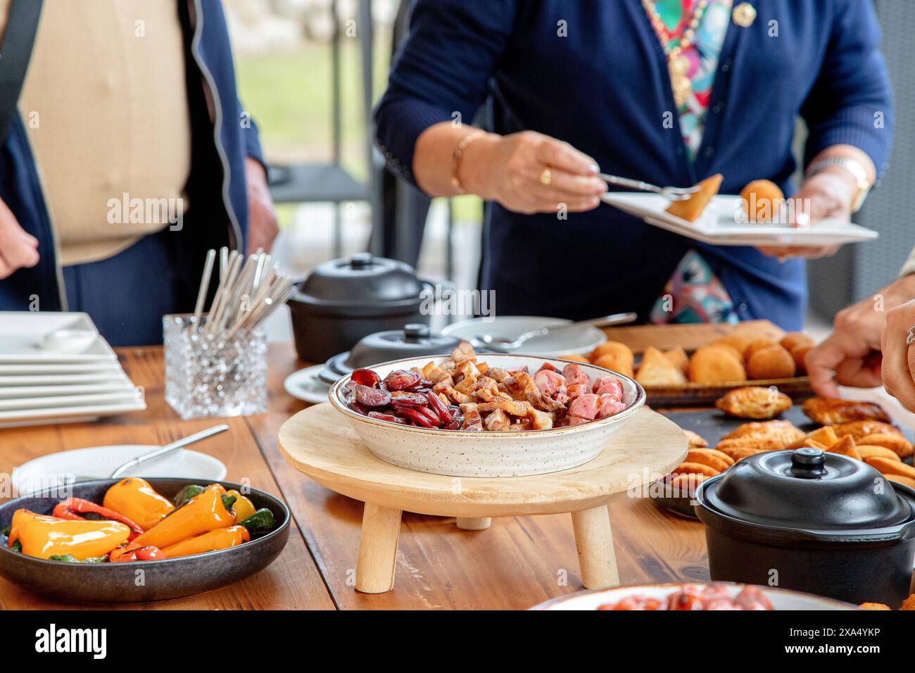 People enjoying a buffet-style meal, serving themselves from a variety ...