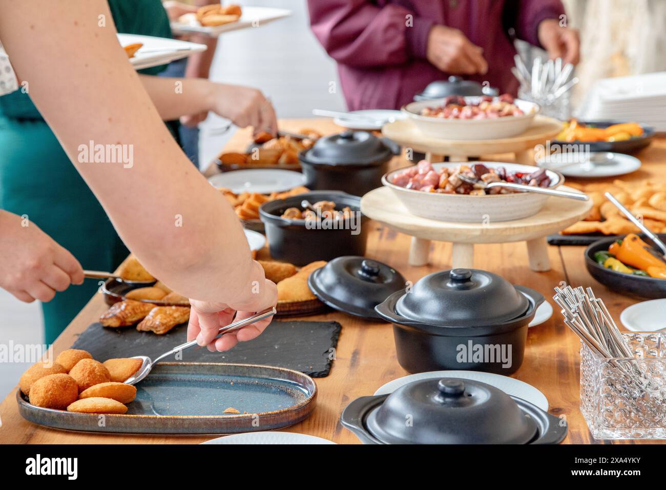 People enjoying a buffet-style meal, serving themselves from a variety ...