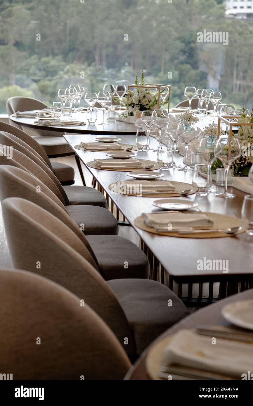 Elegant dining table set for a special event, featuring a beautiful floral centerpiece, wine ...