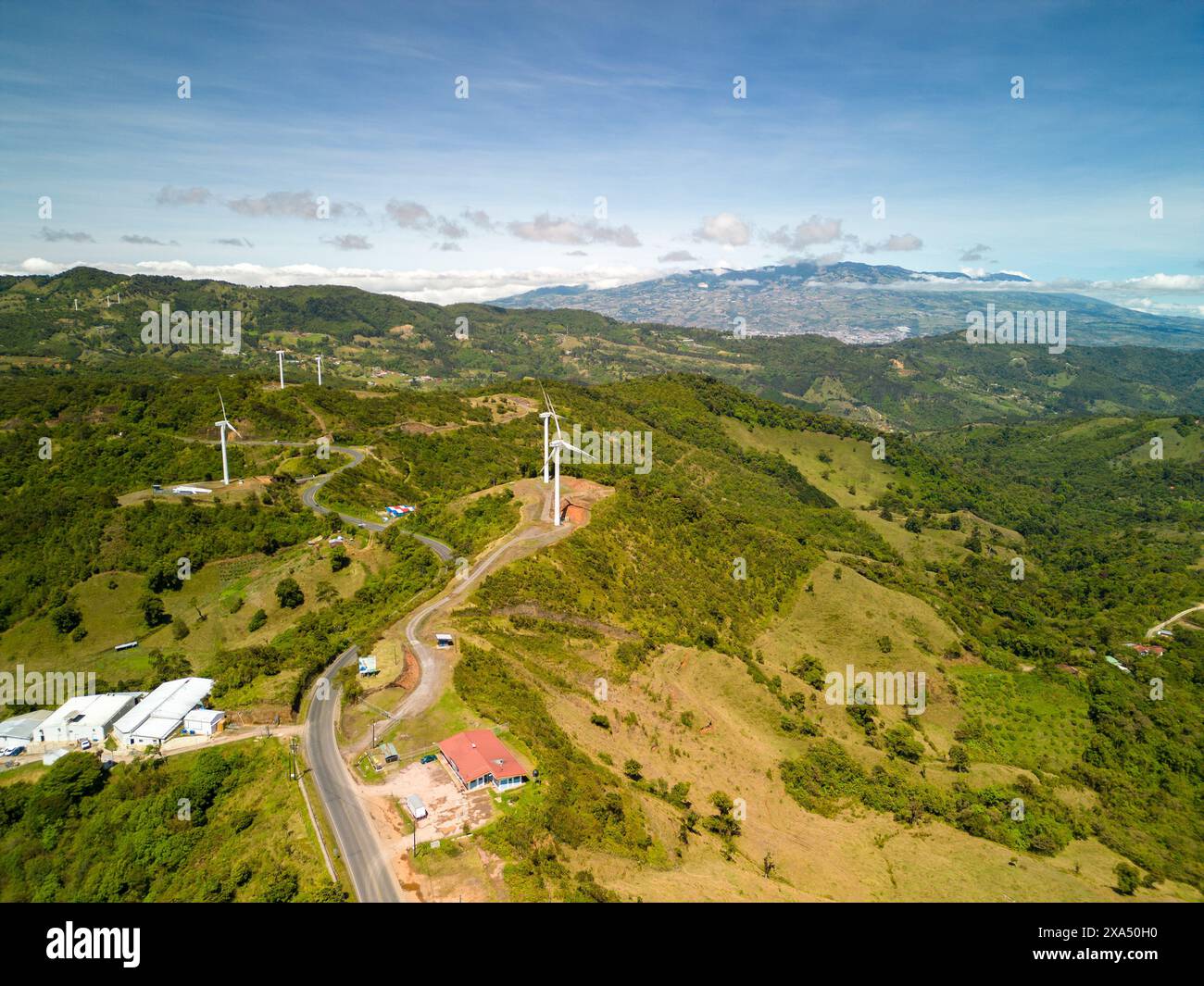An aerial view of wind turbines producing energy in the hills of ...