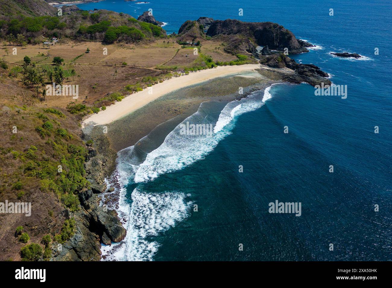 Aerial view of a beautiful, deserted tropical beach surrounded by deep ...