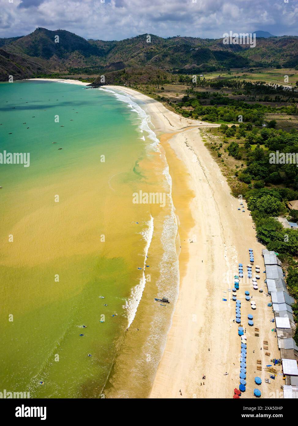 Aerial view of a long, golden sandy tropical beach and warm, muddy ...