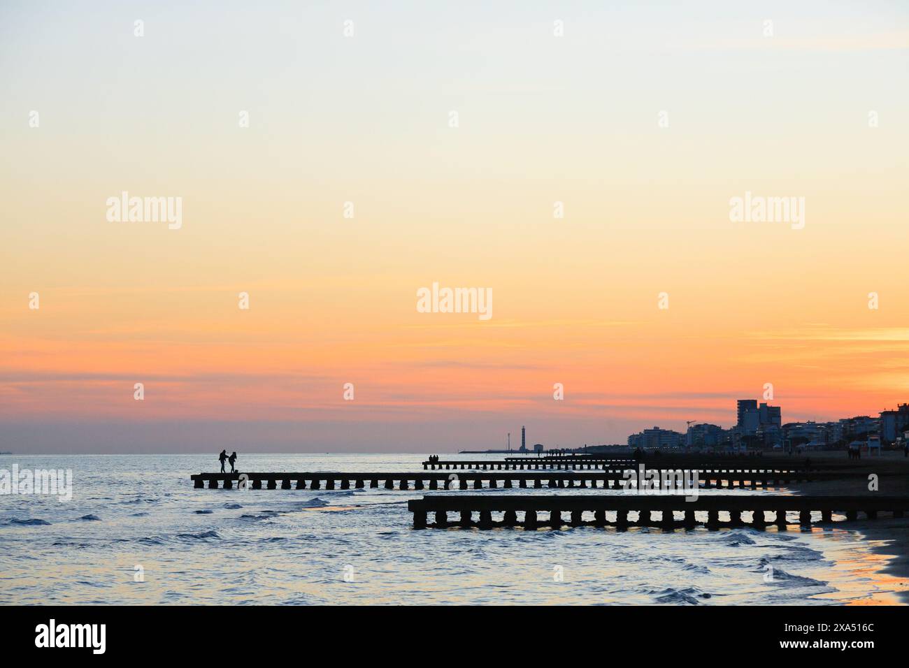 Beach landscape at dawn. Piers perspective view with people. Jesolo ...