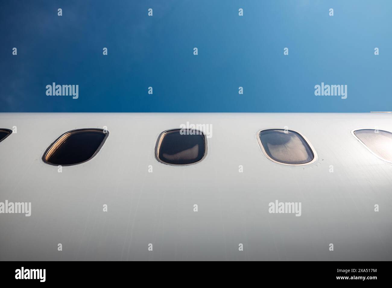 Windows on fuselage of airplane. Plane against clear sky with copy ...