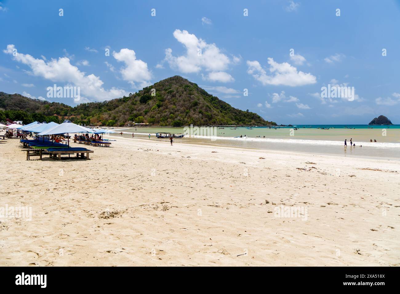 Holidaymakers and surfers on the golden tropical beach of Selong ...