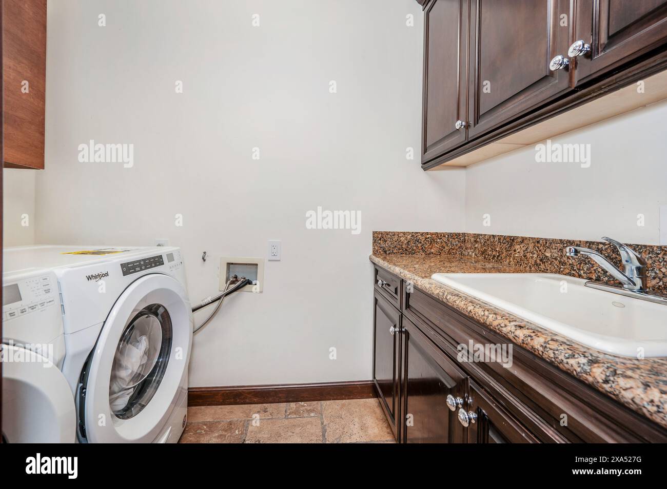 A laundry room with a washer and dryer present Stock Photo - Alamy