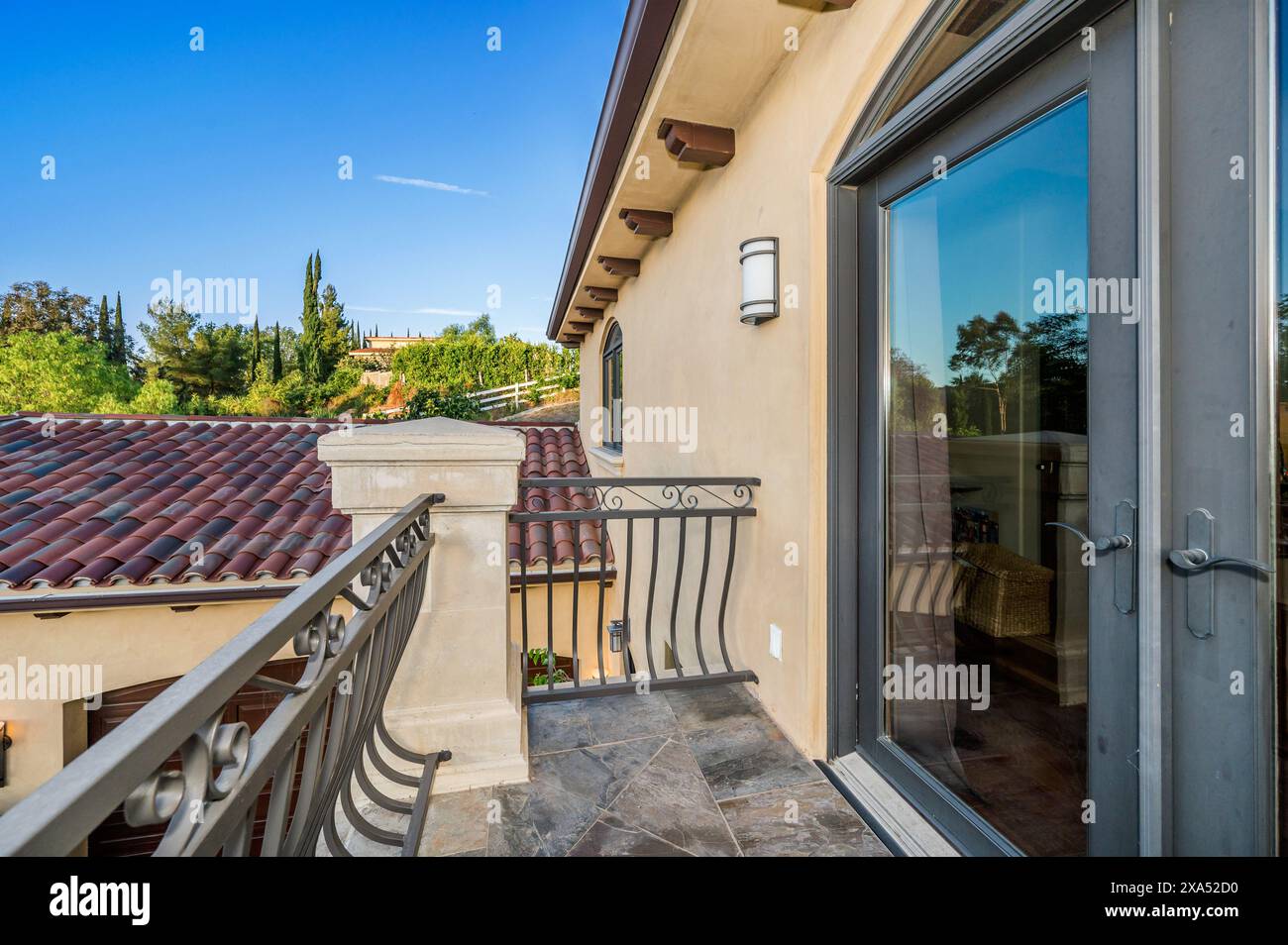Balcony with glass sliding doors and metal bar railing Stock Photo - Alamy
