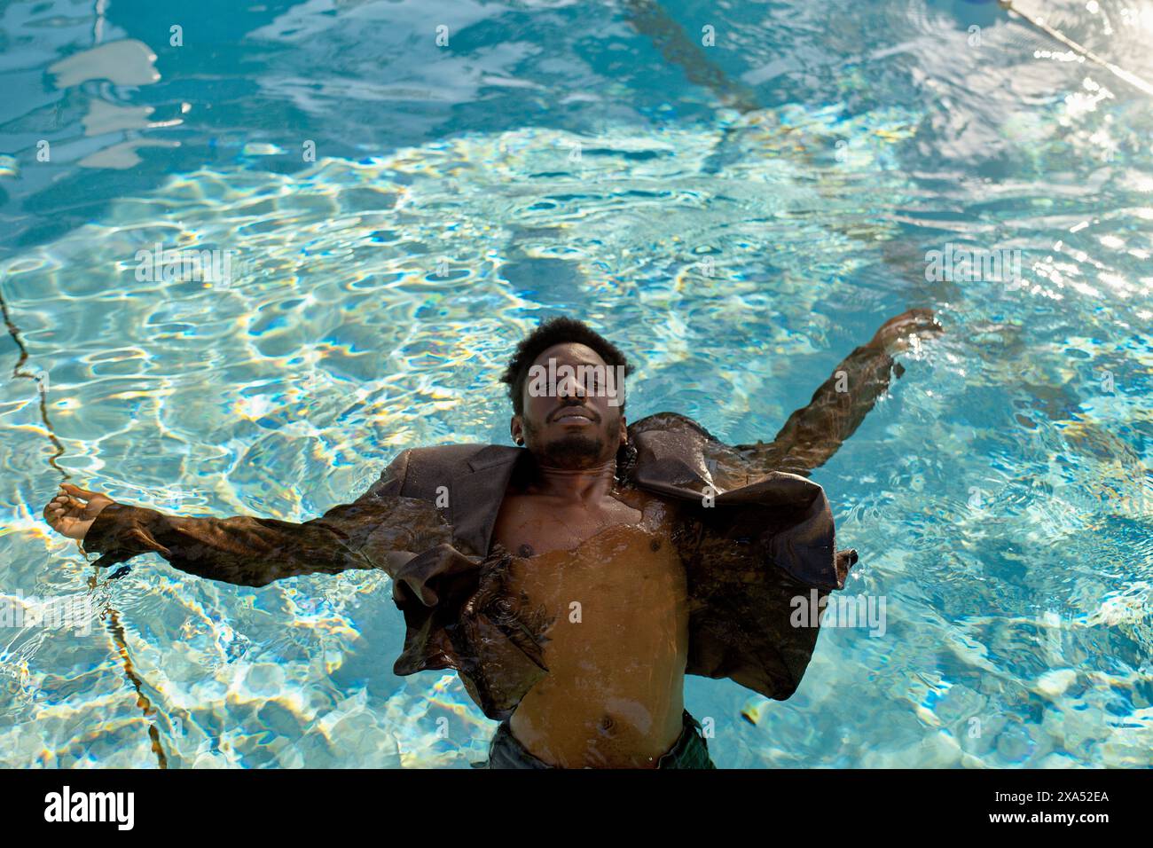 A man calmly floating on his back in a clear swimming pool while ...