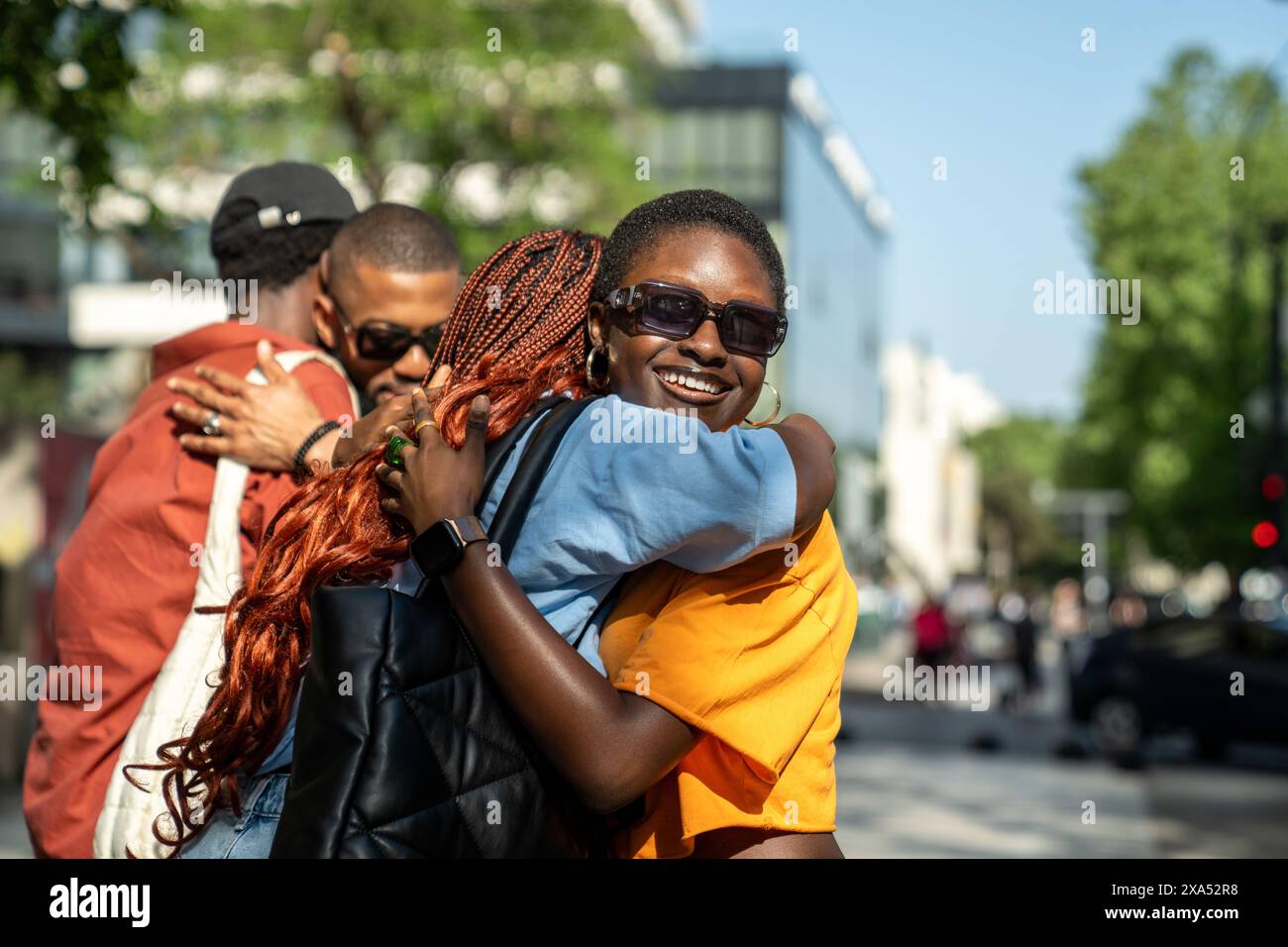 Joyful black students in good mood hugging each other in friendly ...