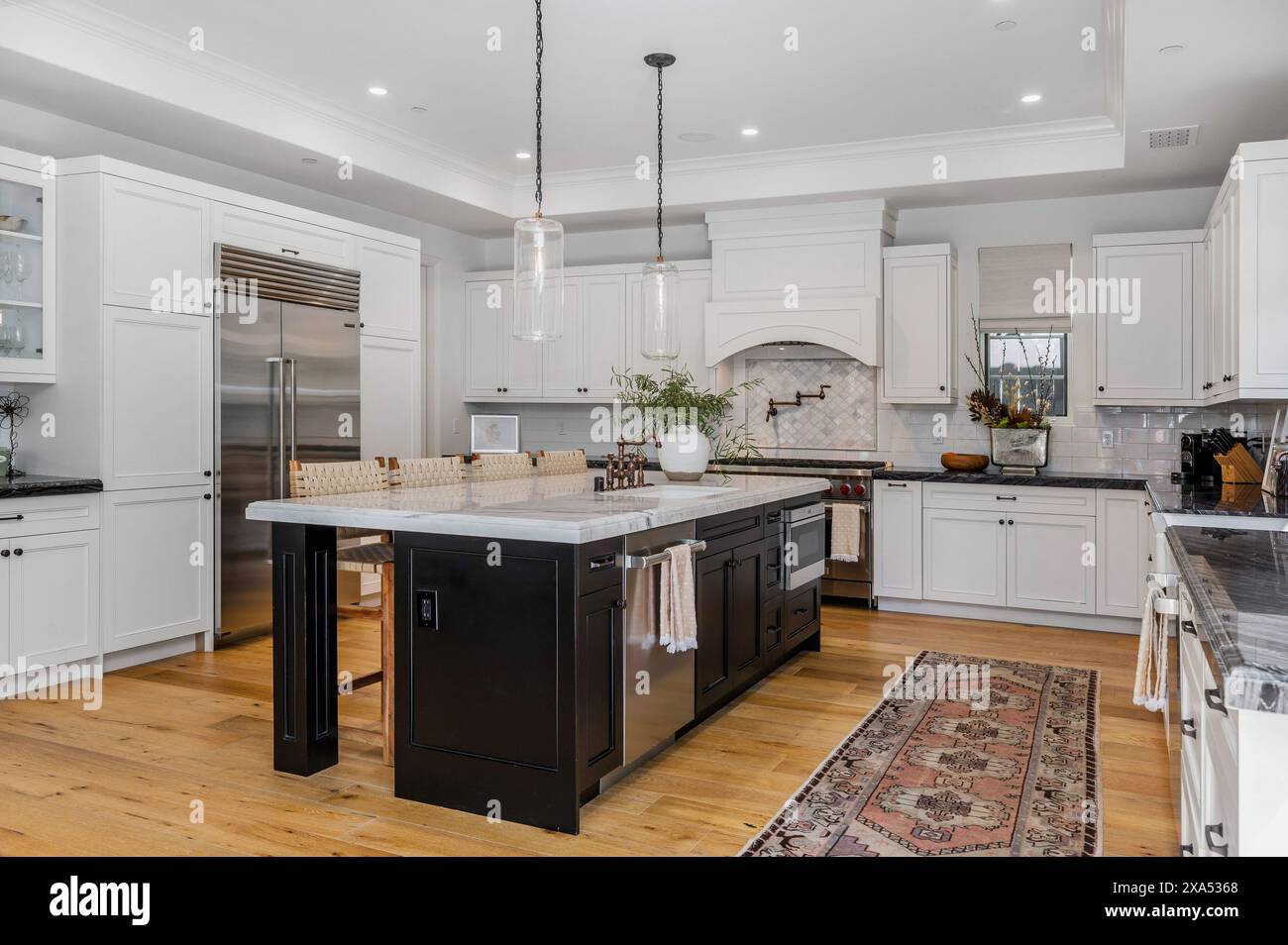 Kitchen with a table surrounded by chairs and a sleek countertop Stock ...