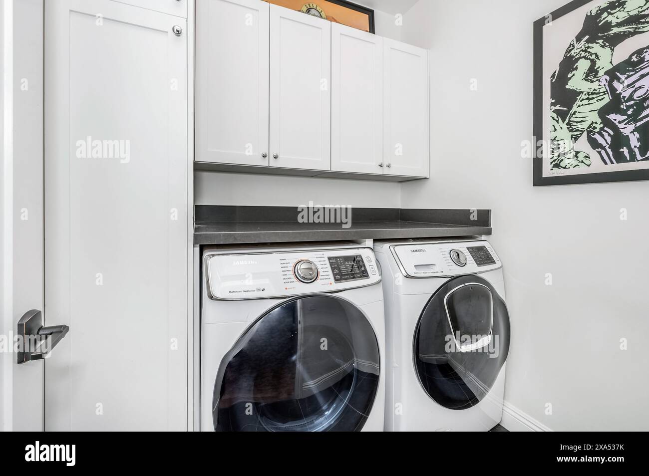 A clothes dryer beneath overhead cabinets Stock Photo - Alamy