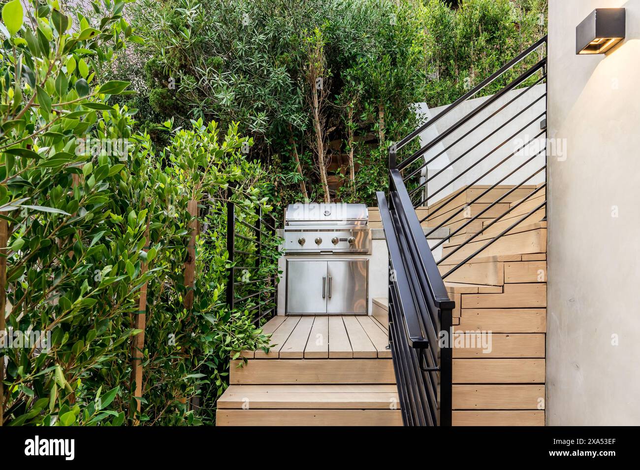 Grill on outdoor patio near steps to wooden deck Stock Photo - Alamy