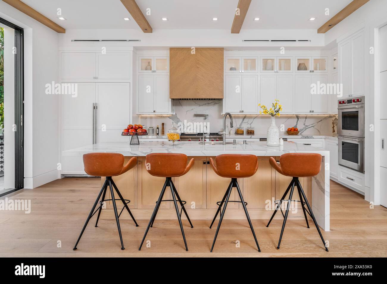 Three orange stools in a contemporary white kitchen with wooden beams ...