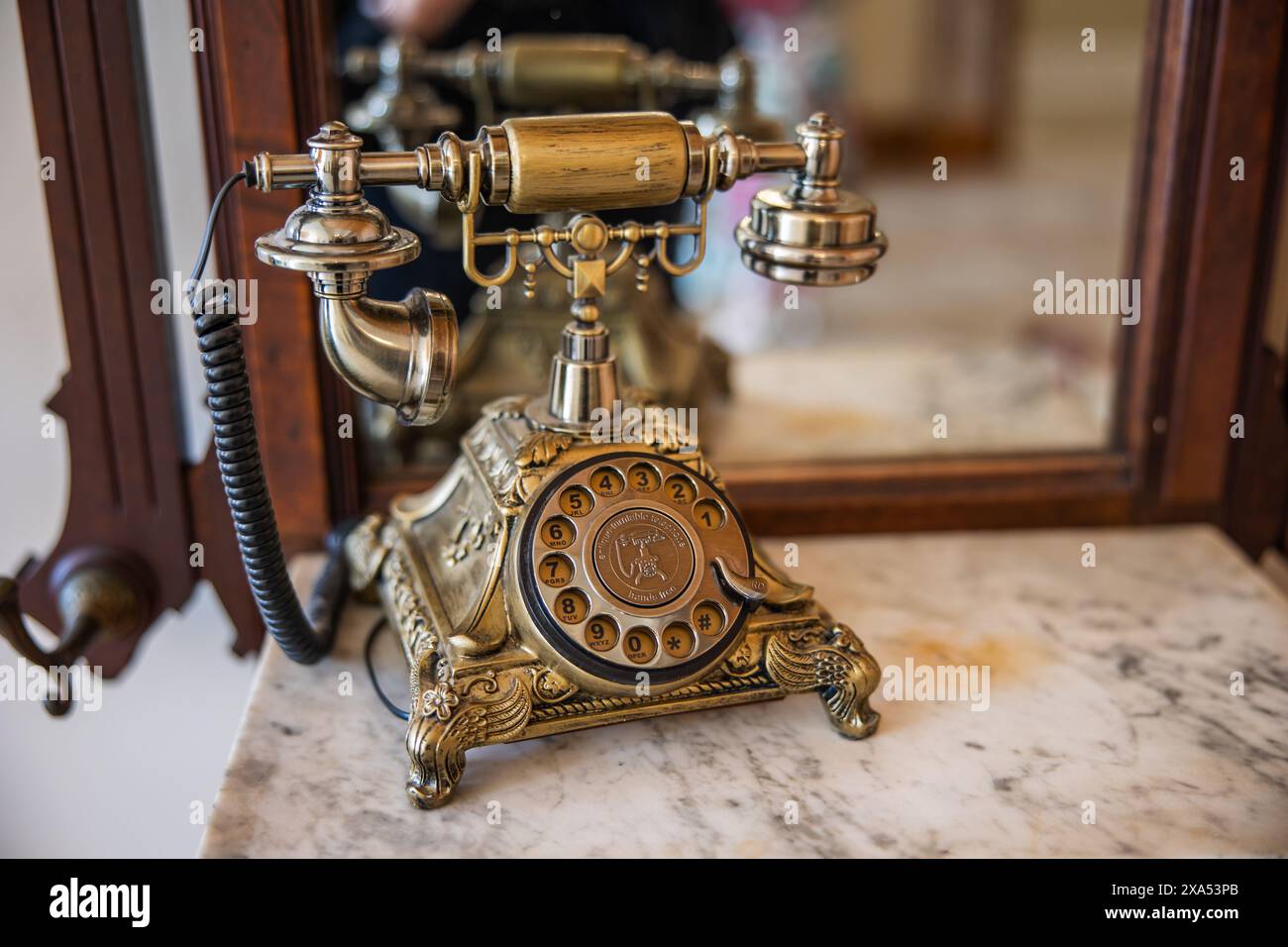 An old vintage antique gold dial up telephone for communication sitting ...
