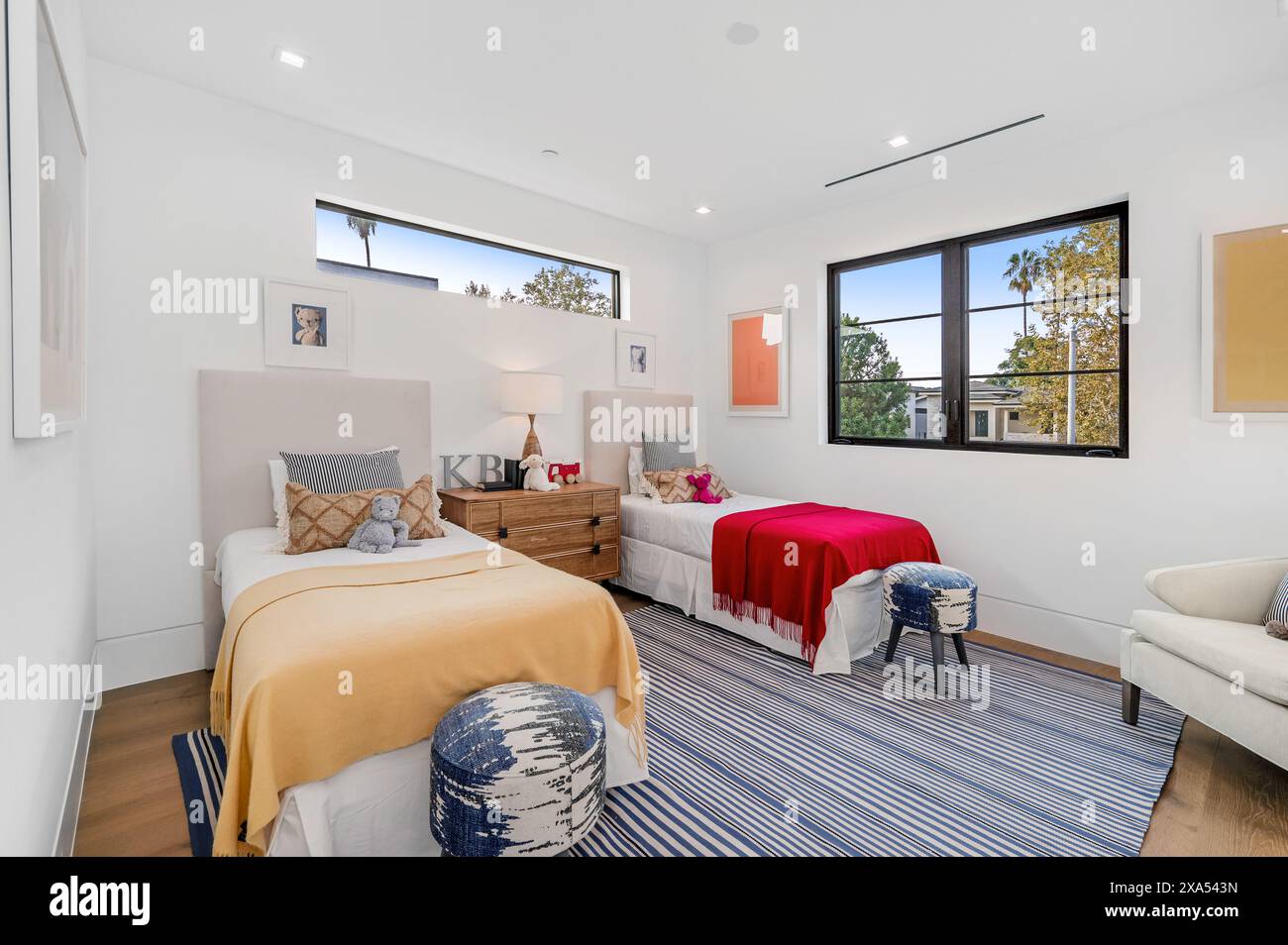 Two beds nestled in a bedroom corner under windows Stock Photo - Alamy