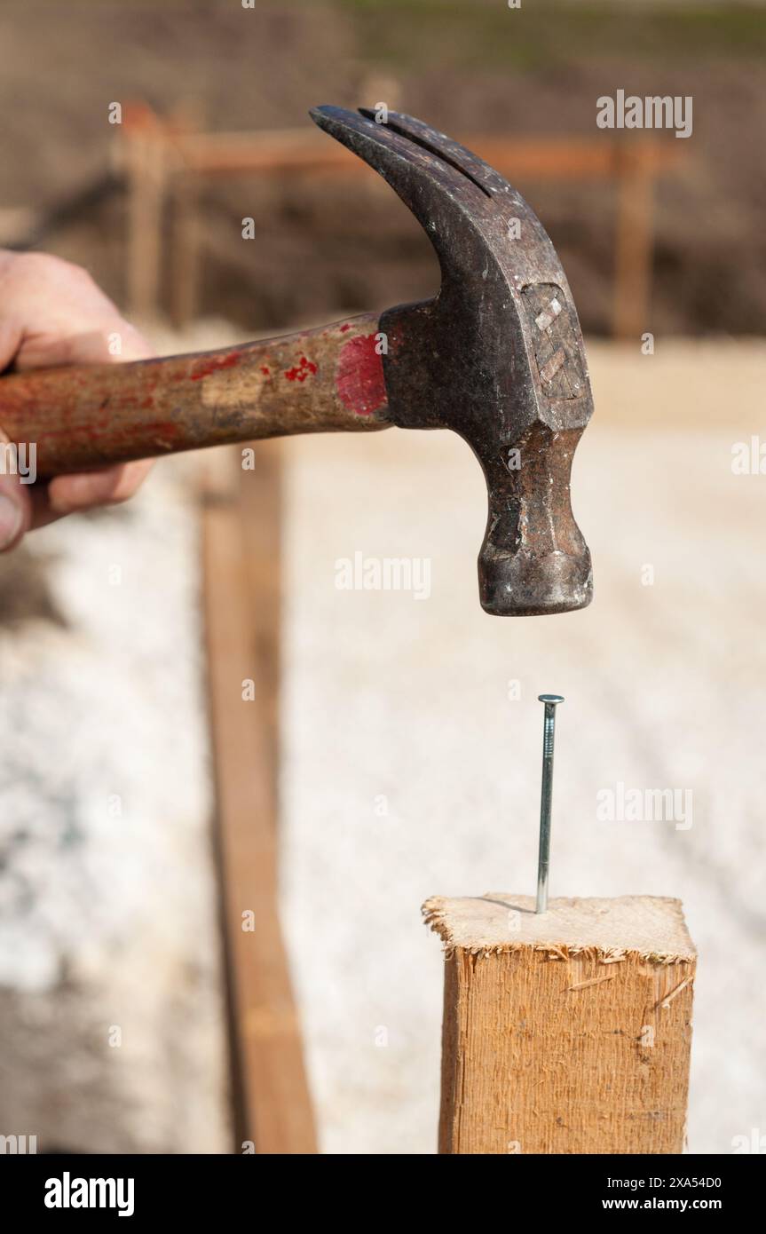 A man using a hammer for nailing on a construction site in southern ...