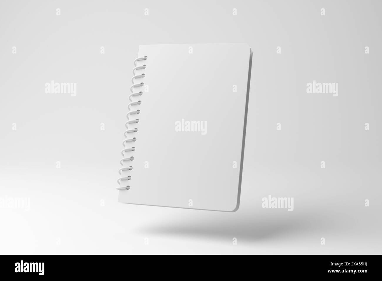 White spiral lined notebook floating in mid air on white background in ...