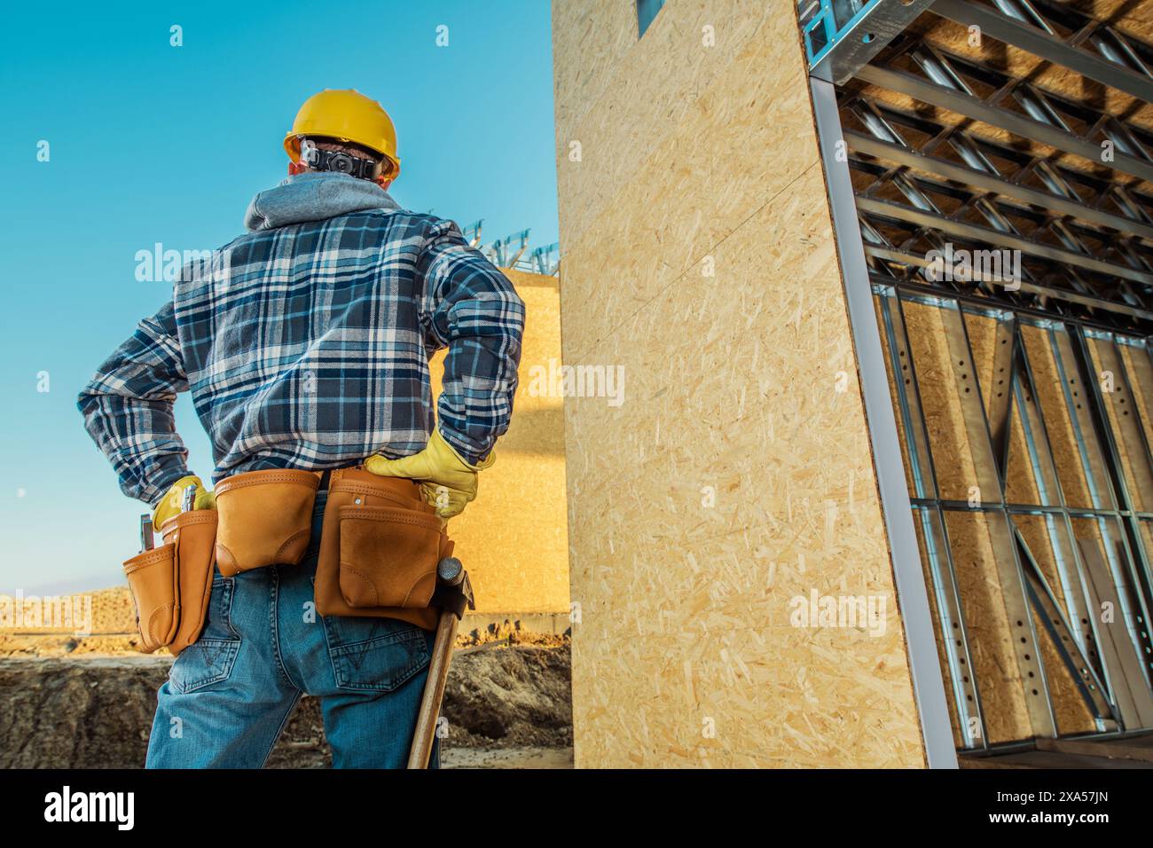 A construction worker working on a building site with a wall in ...