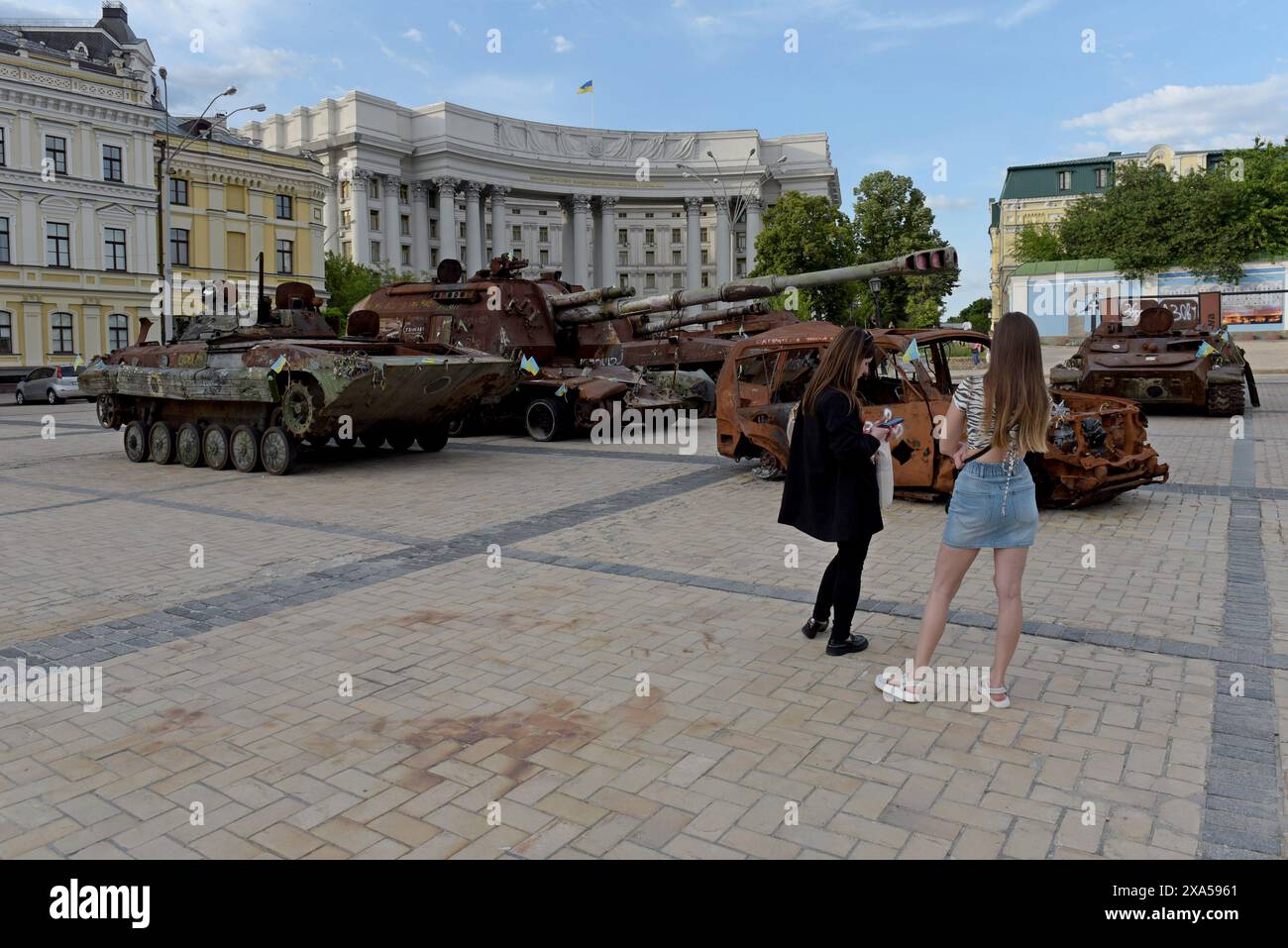 People looking at the remains of destroyed and captured Russian tanks ...