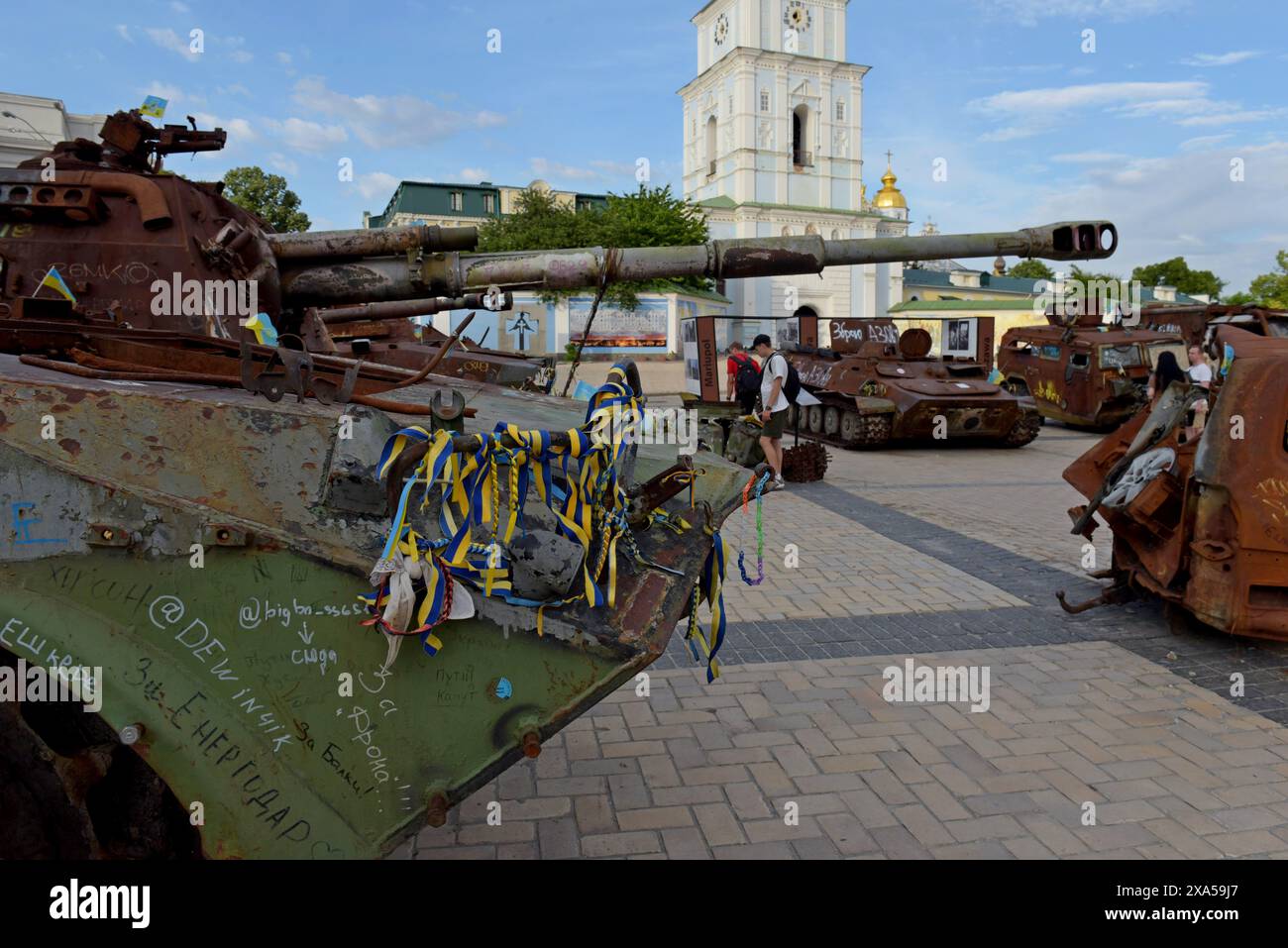 People looking at the remains of destroyed and captured Russian tanks ...