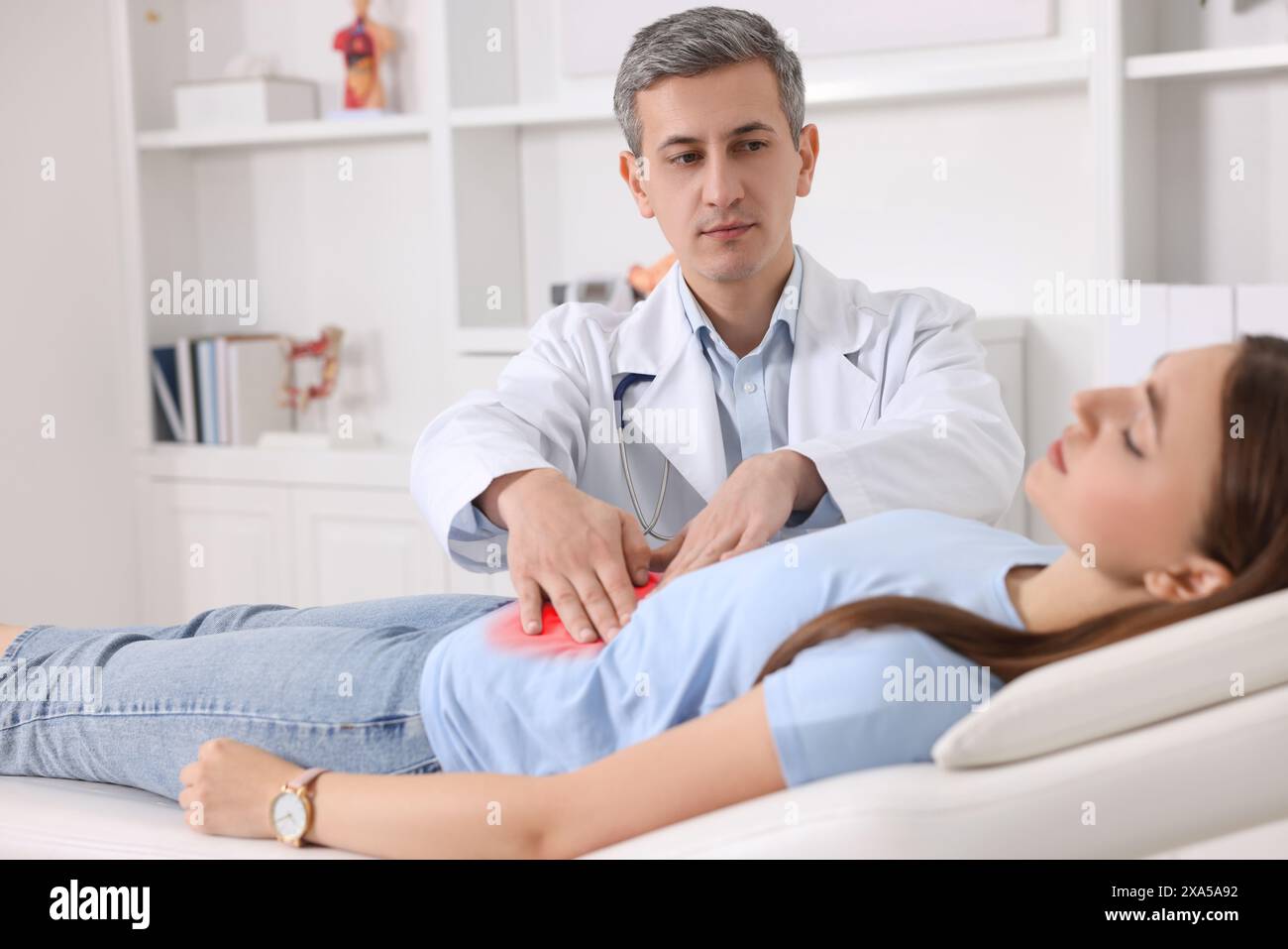 Gastroenterologist examining patient with stomach pain on couch in ...