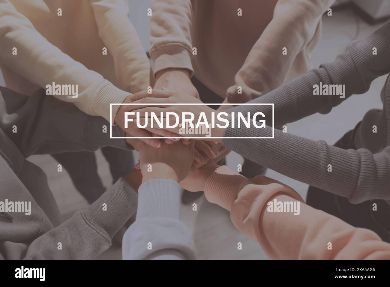 Group of people holding hands together indoors. Fundraising Stock Photo ...