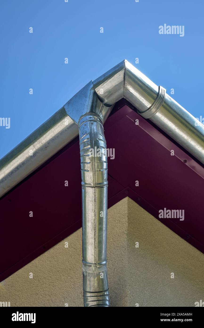 Part of roof with galvanized pipe and gutters for draining rainwater ...
