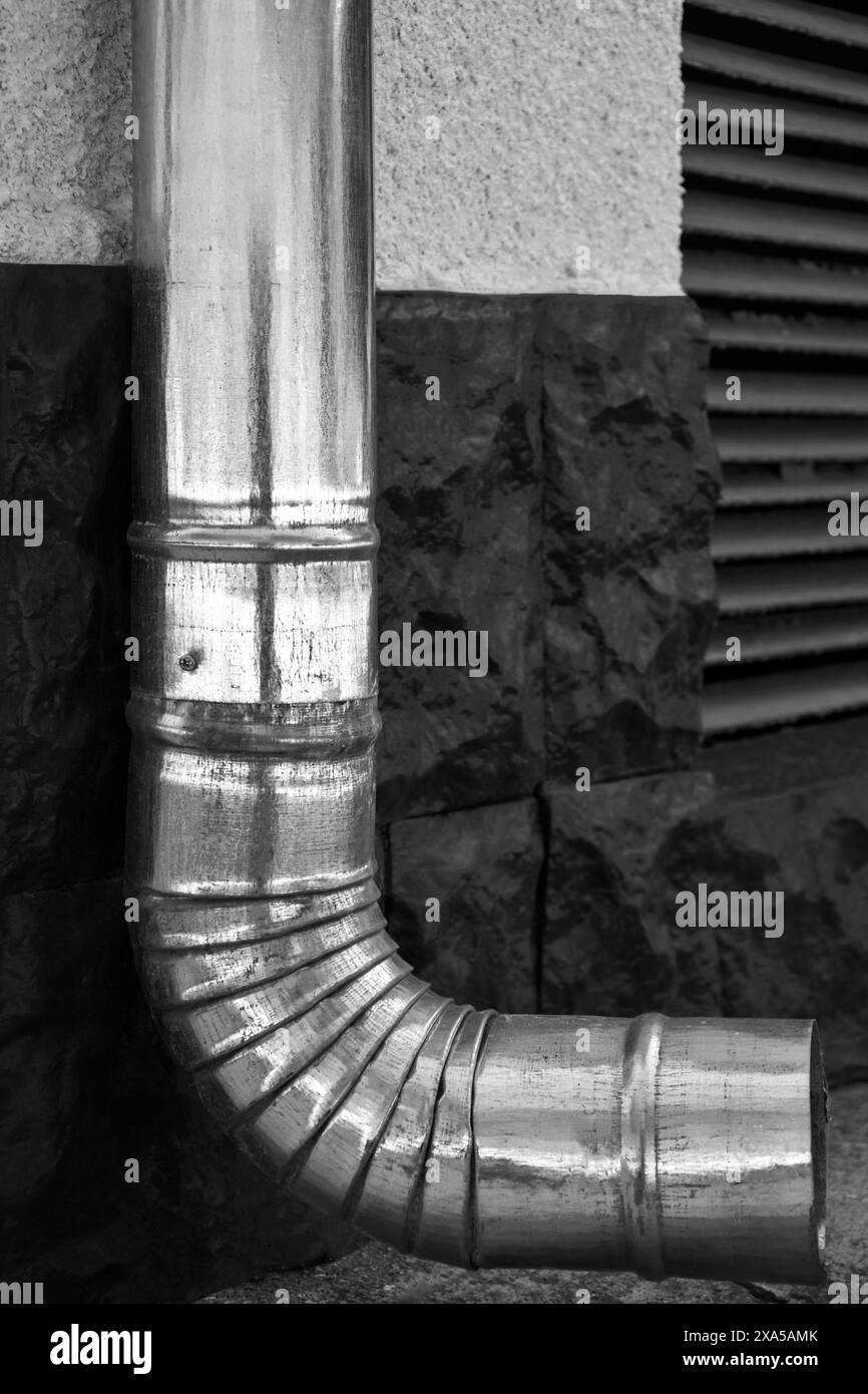 Part of wall with galvanized pipe for draining rainwater. Side view ...