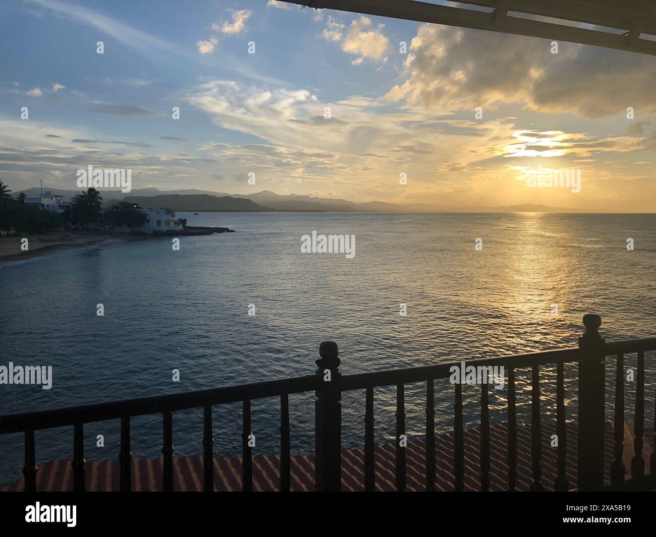 The sun setting over water with distant mountains in Dominican Republic ...