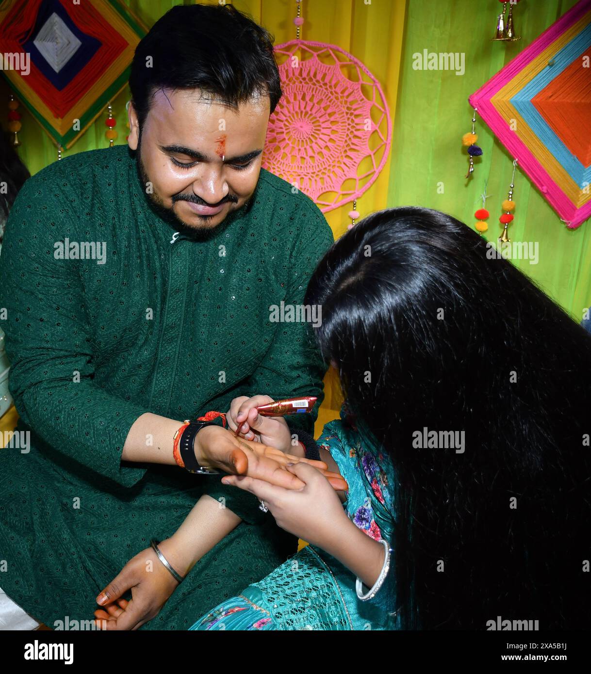 Two people standing with hands touching, holding out an object together ...