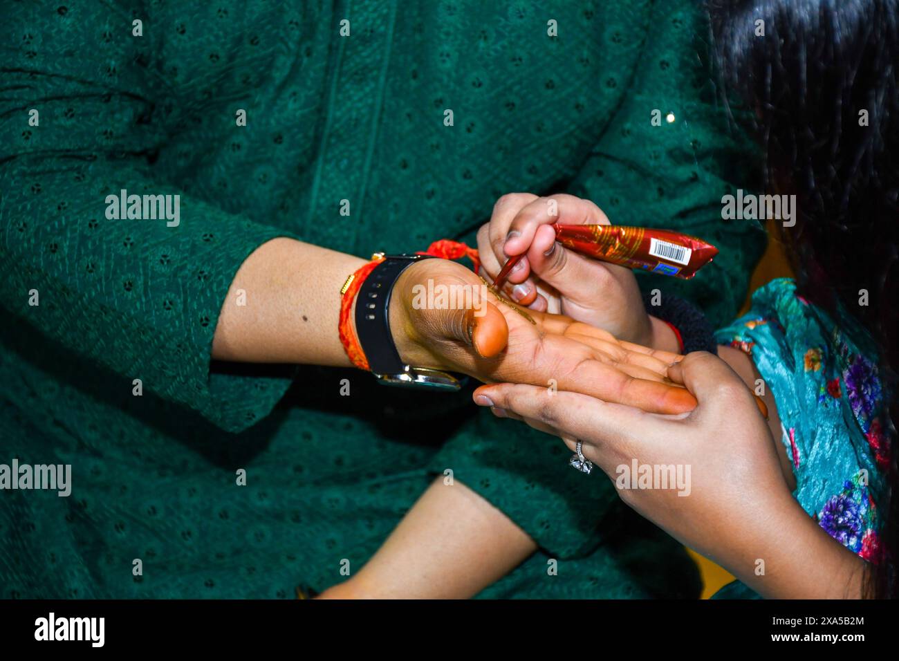 Two people standing with hands touching, holding out an object together ...